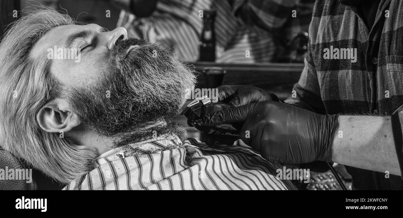 Personal care. Concept Barbershop. Young hipster man with beard cutting ...