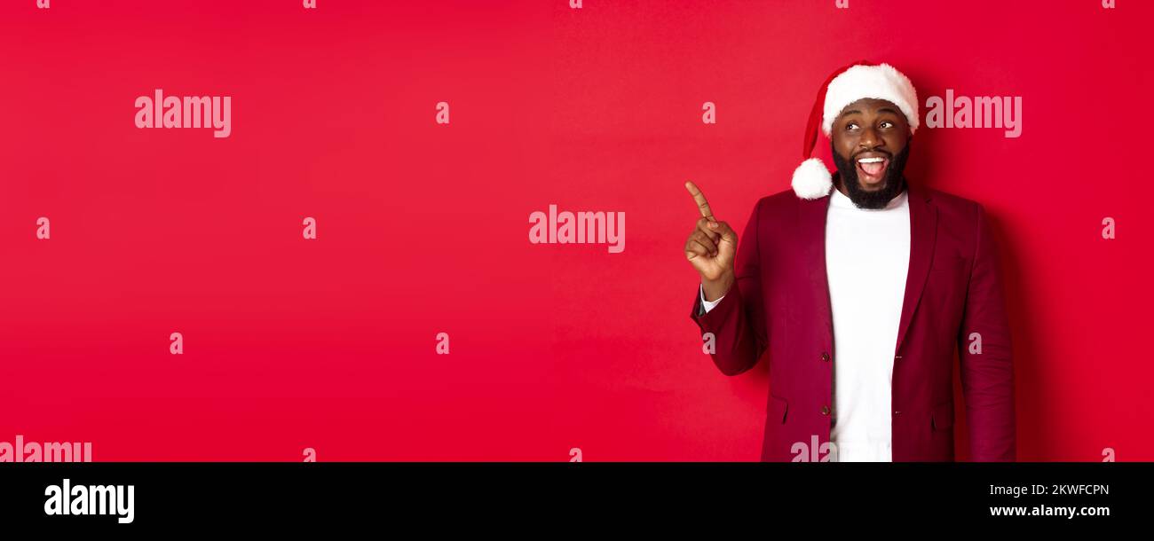 Christmas, party and holidays concept. Cheerful Black guy in santa hat ...