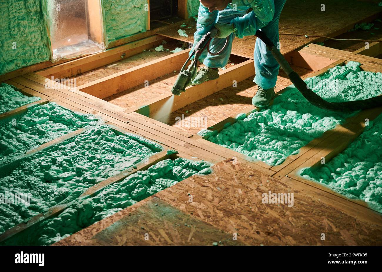 Male builder insulating wooden frame house. Cropped view of man worker ...