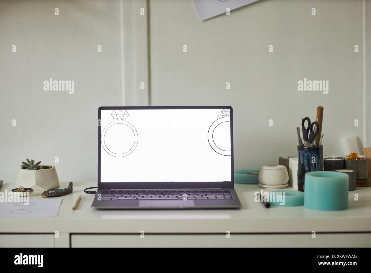 Close up of open laptop with jewelry designs at screen in minimal ...