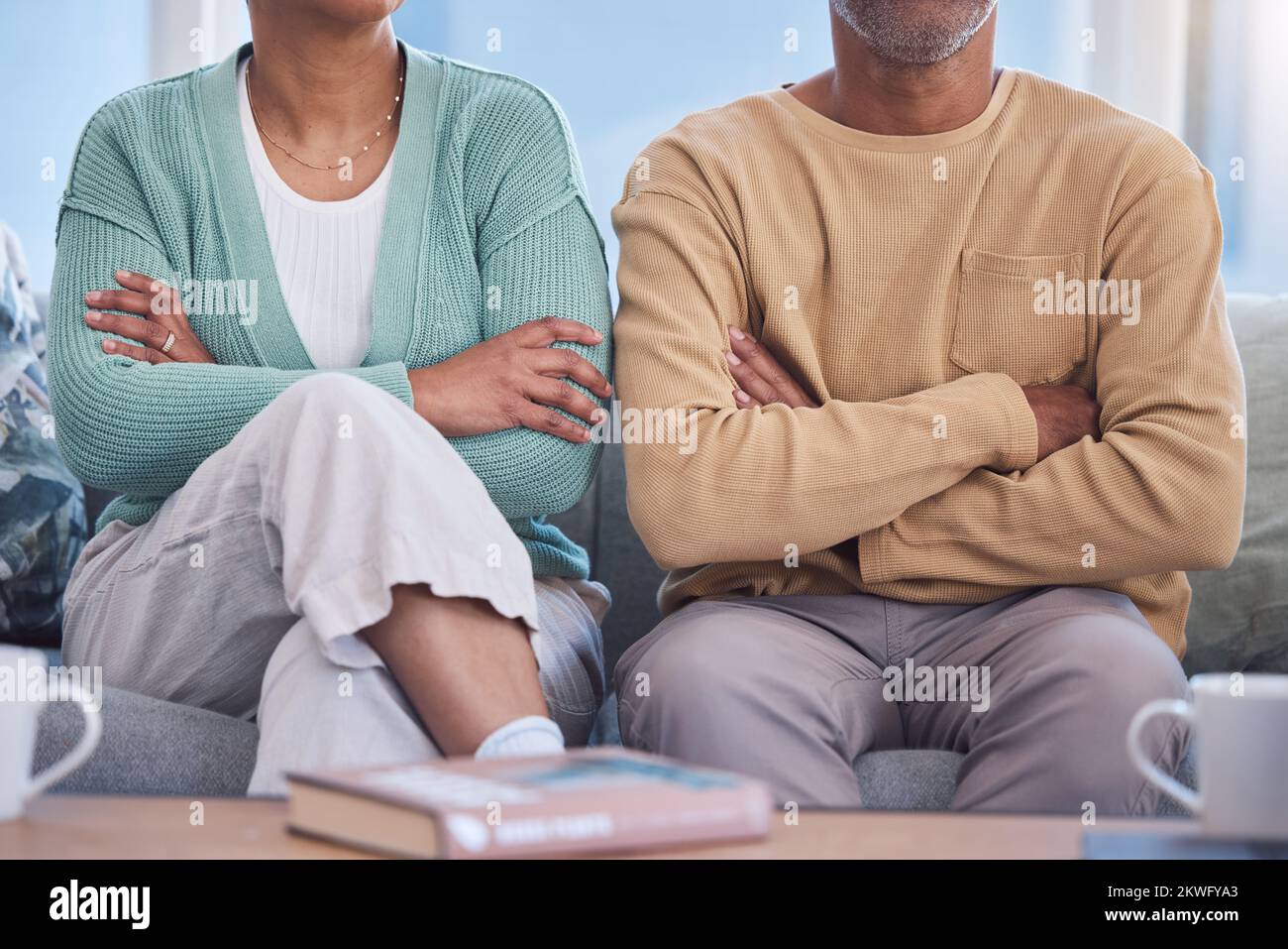 Angry, upset and annoyed with a couple sitting arms crossed on a sofa ...