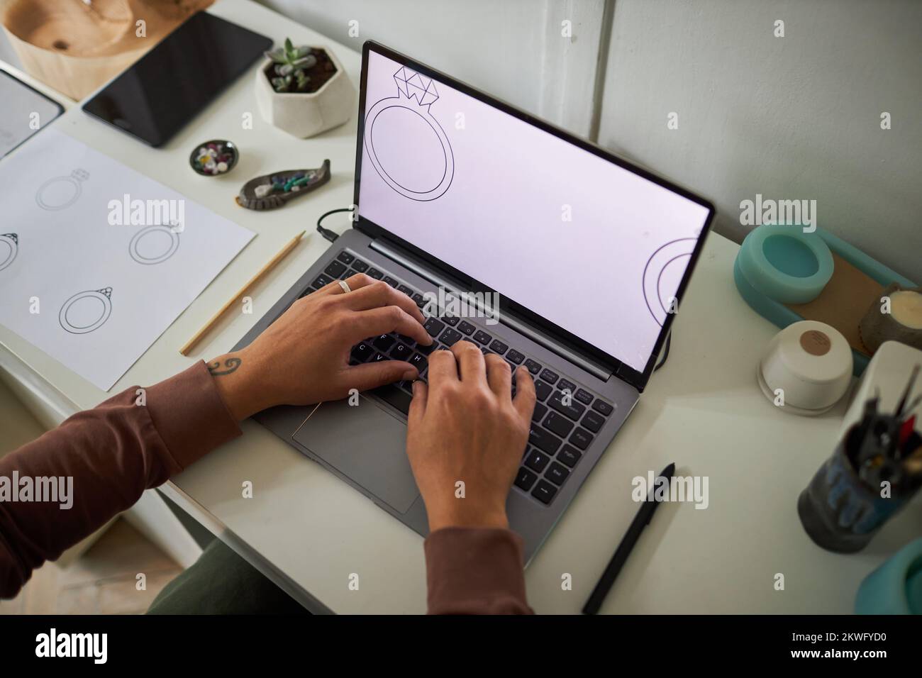 Top view closeup of creative artist typing at laptop keyboard and ...