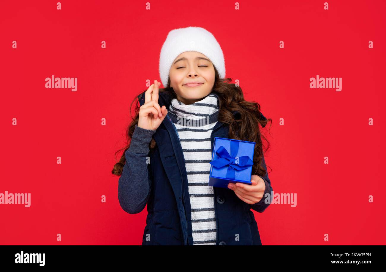 happy child in puffer jacket and hat hold box. kid with present. teen ...