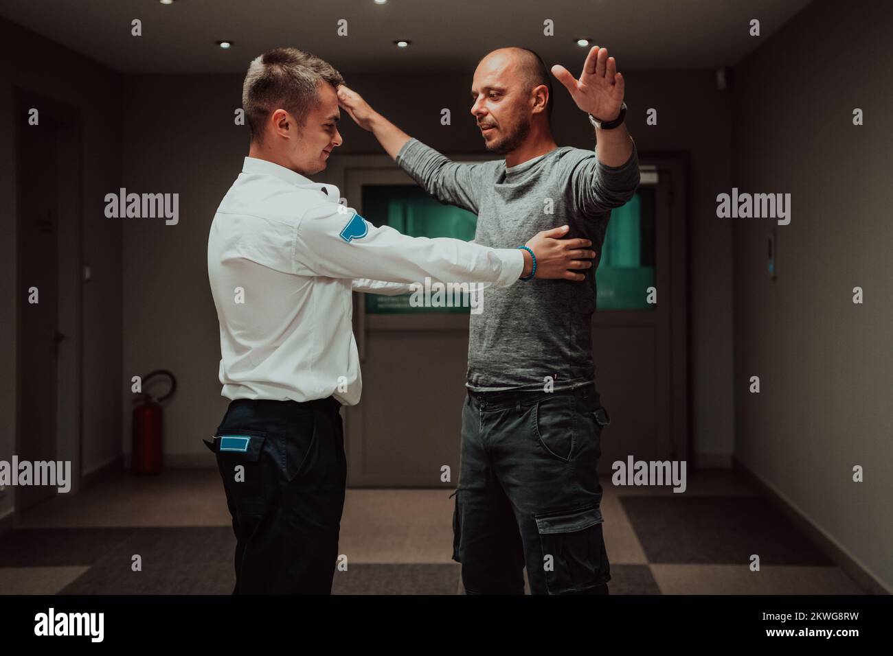 Security guard making body searching procedure on man for finding ...