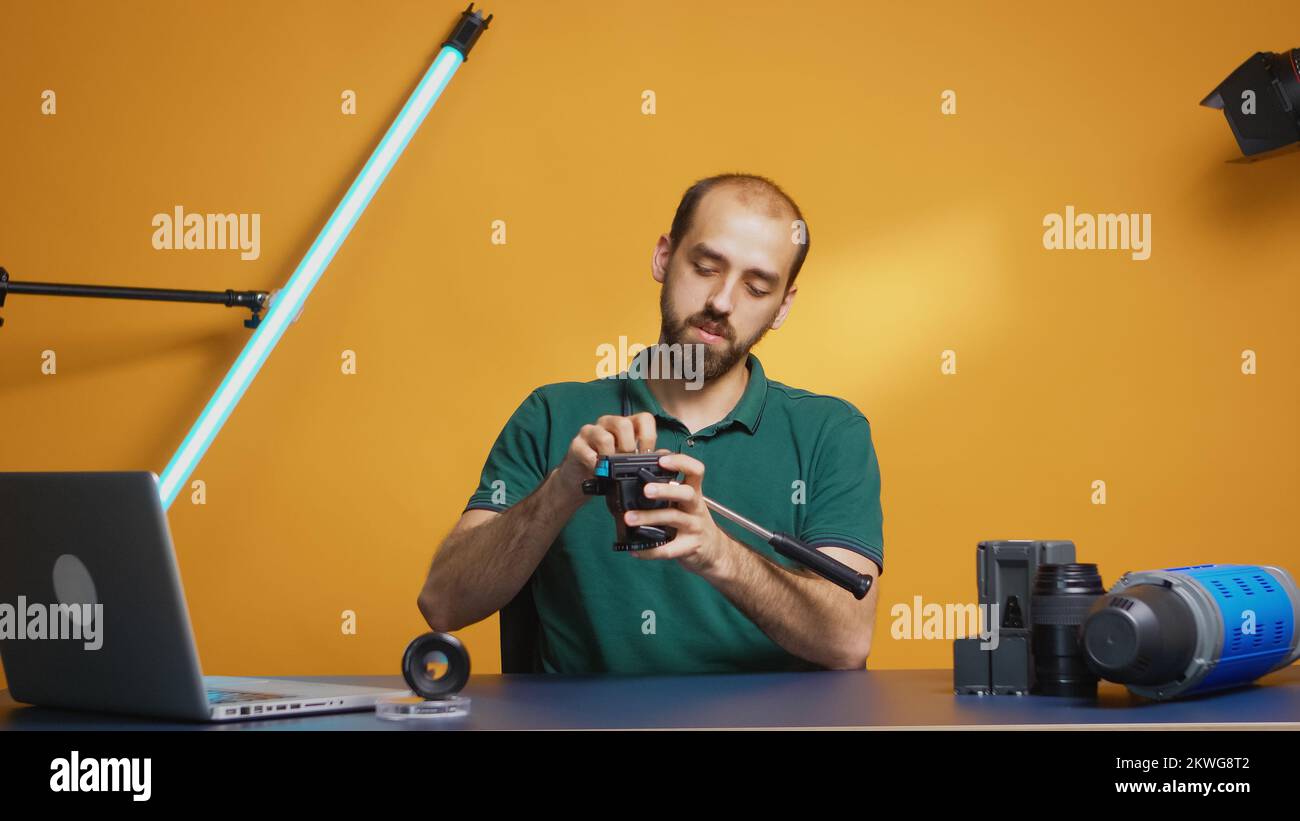 Videographer recording tutorial about tripod head with fluid head ...