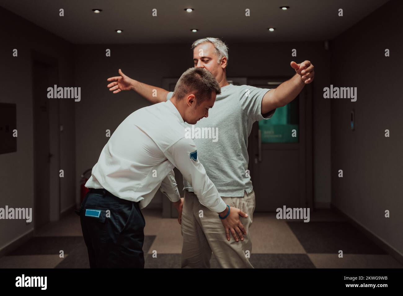 Security guard making body searching procedure on man for finding ...