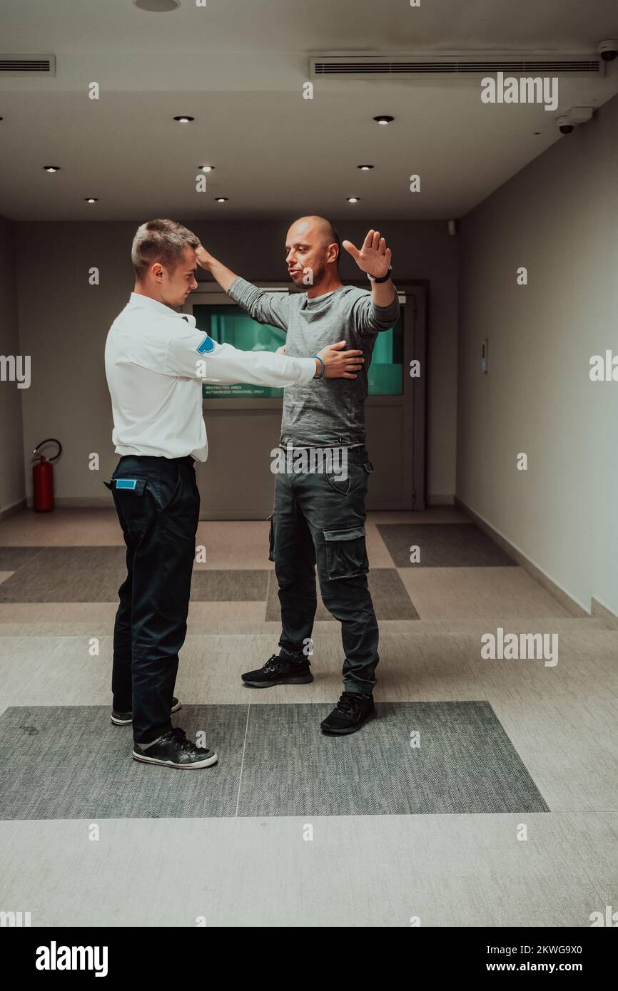 Security guard making body searching procedure on man for finding ...