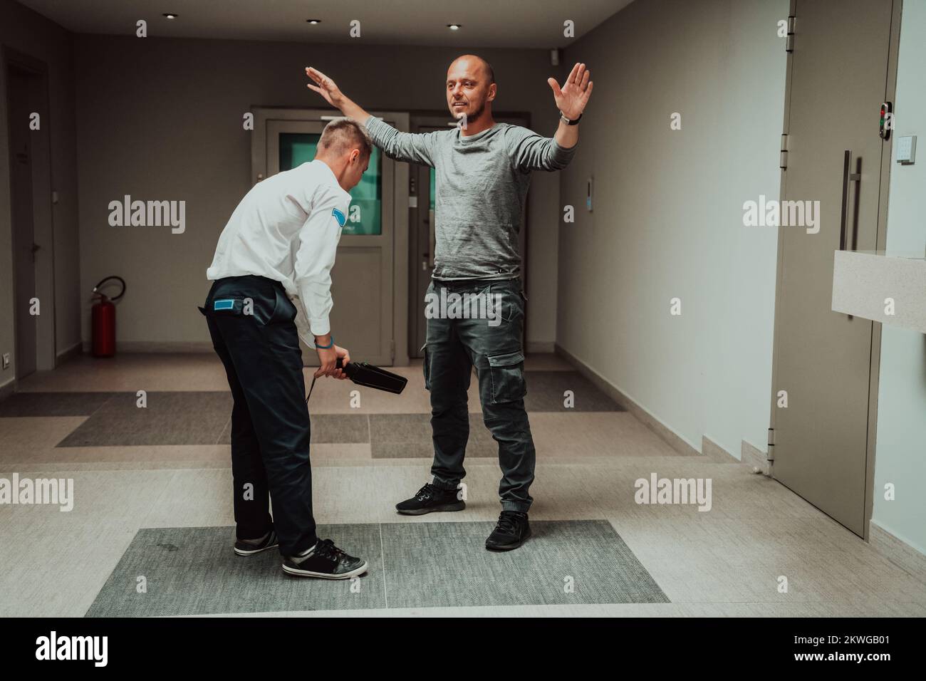 Security guard making body searching procedure on man for finding ...