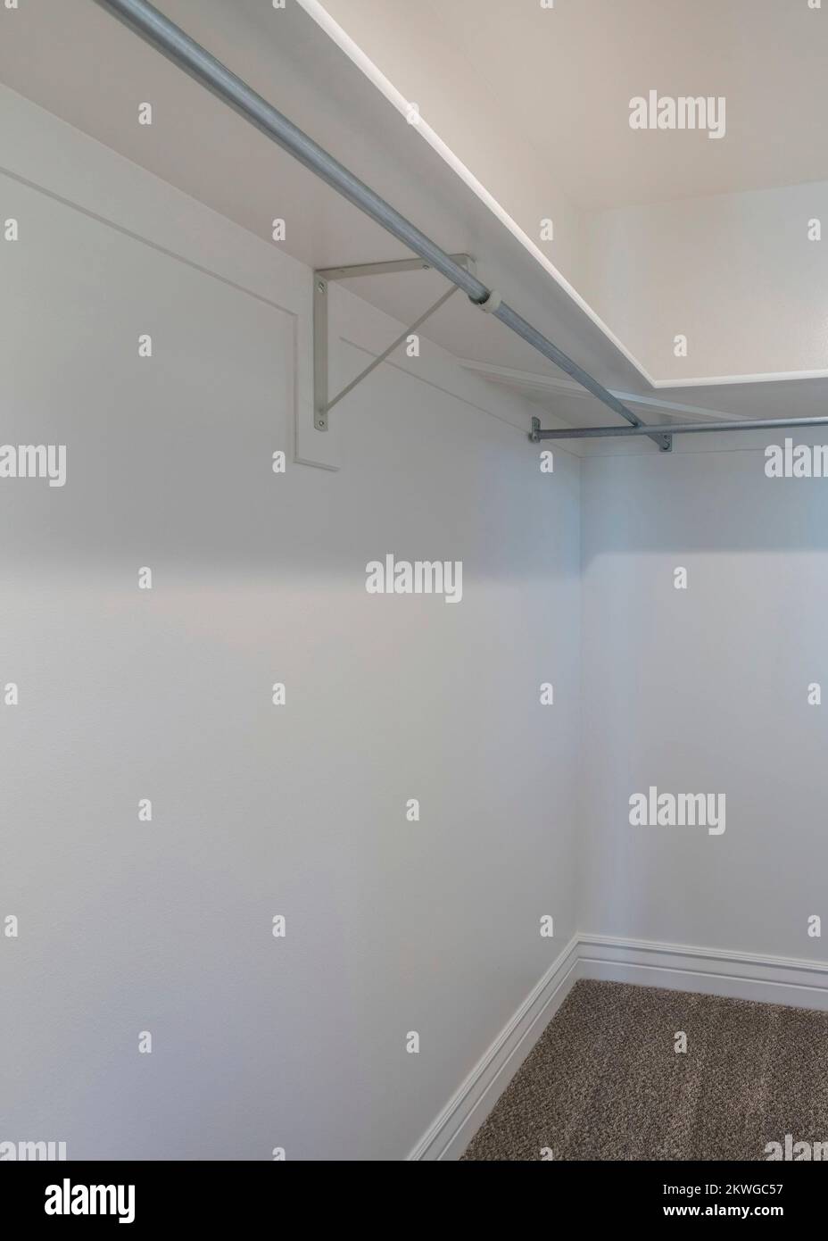 Vertical Small empty walk in closet with white interior and window ...