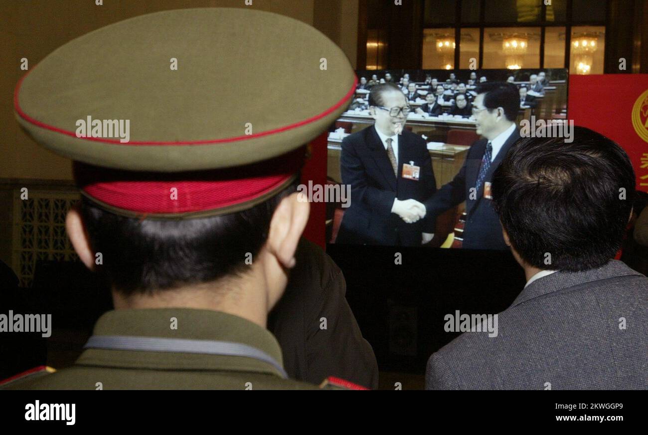 A PLA soldier watches as Jiang Zemin shakes hands with Hu Jintao after ...