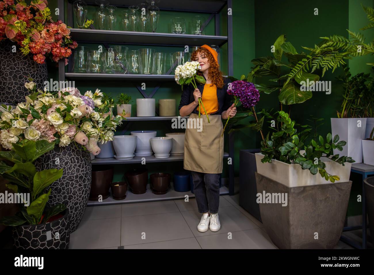 Cute smiling girl with flowers looking enjoyed Stock Photo - Alamy