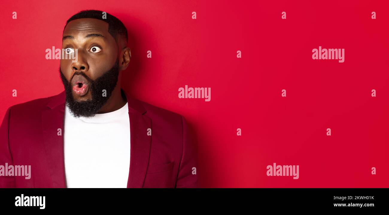 Close-up of impressed Black man looking left at copy space, saying wow ...