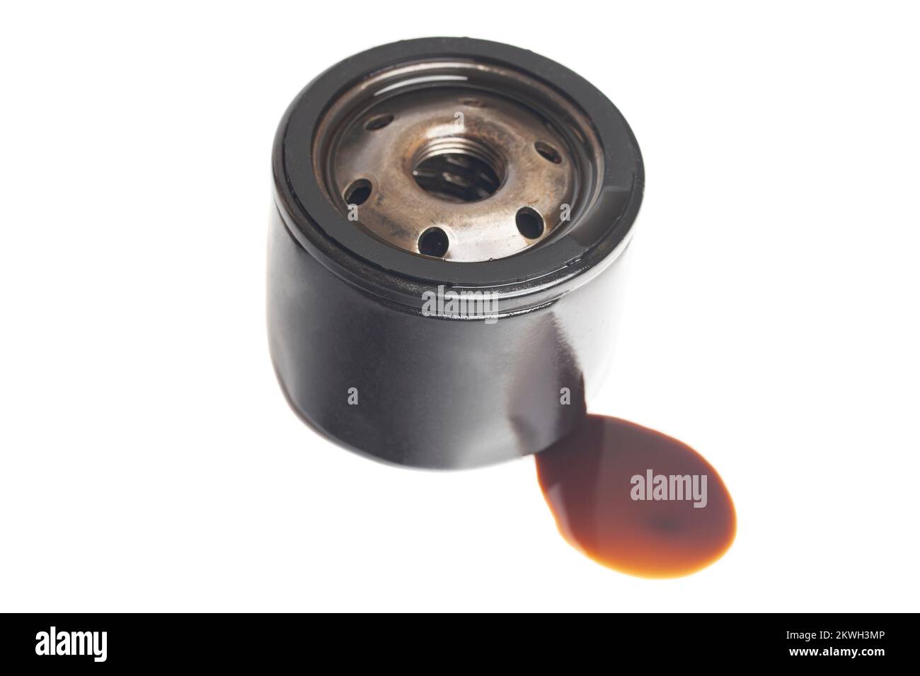 Car oil filter with a puddle of engine oil isolated on white background ...