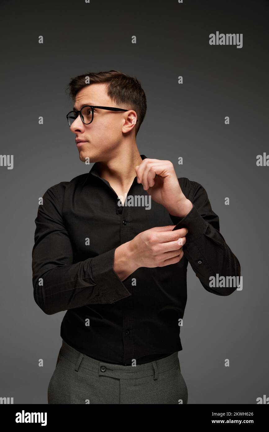 Successful young man in business classic style outfit adjusting his ...