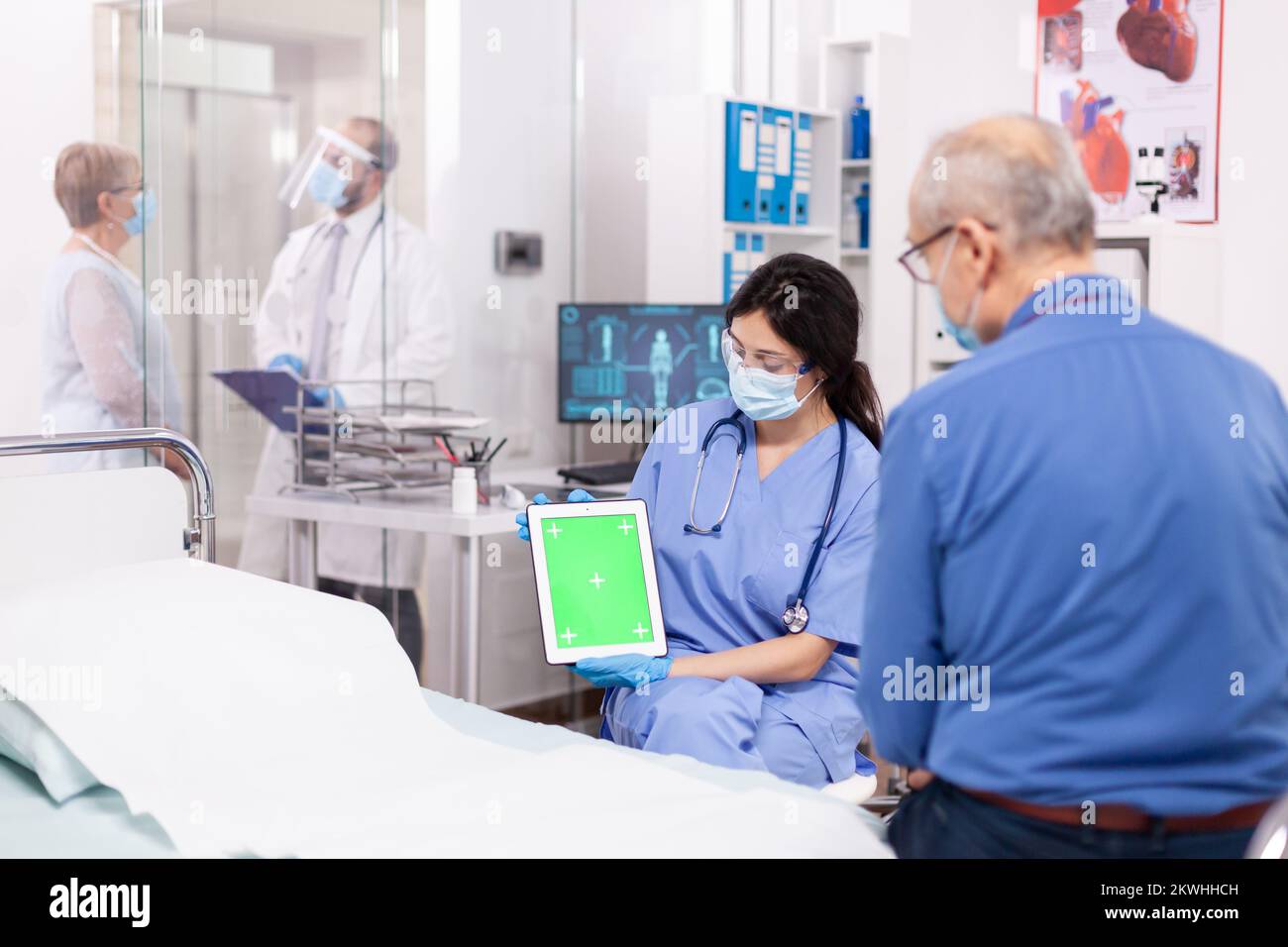 Patient looking at tablet with green screen during consultation in ...