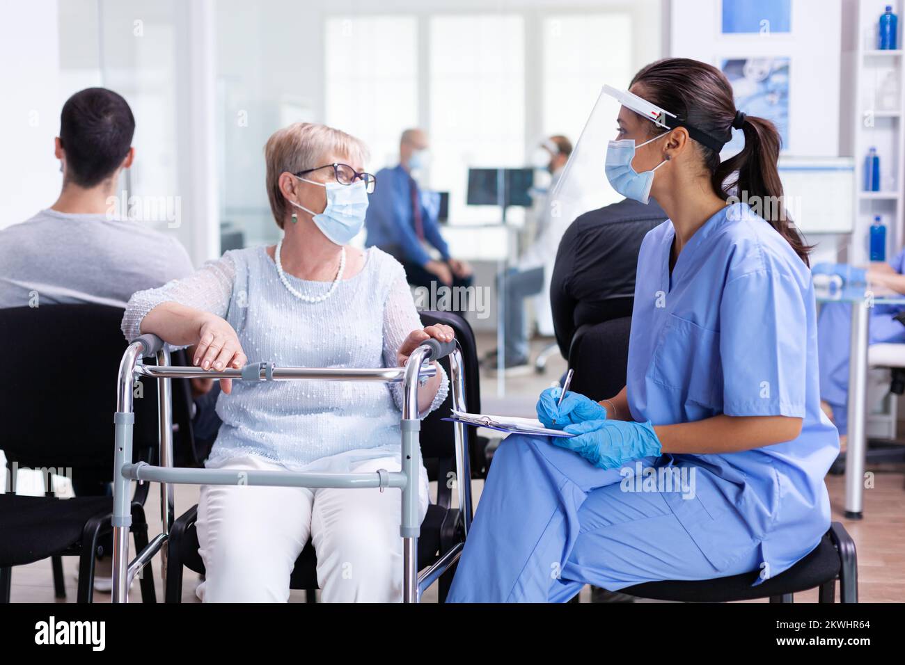 Nurse explaining diagnosis to disabled senior woman with walking frame ...