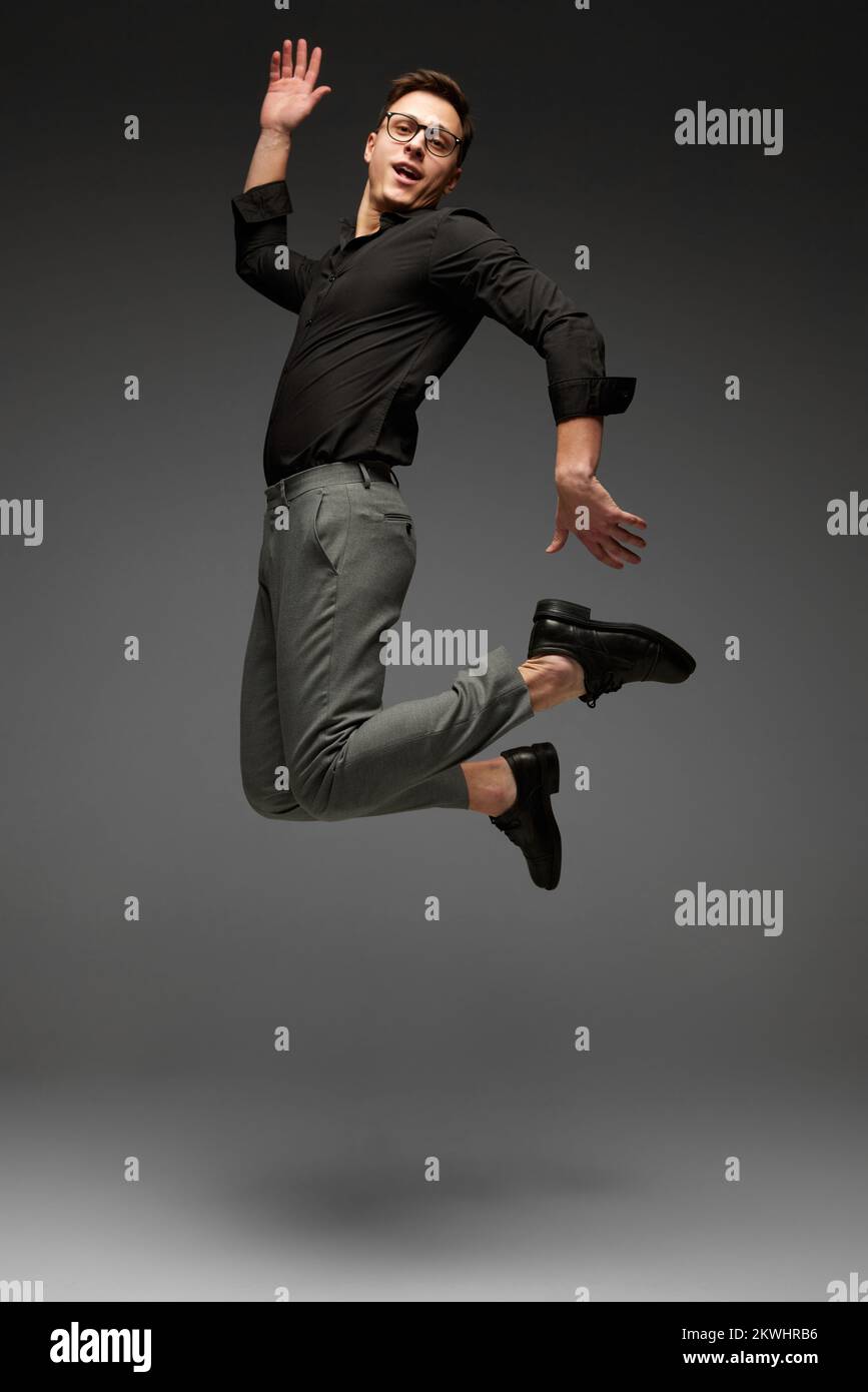 High jumps. Happy young man, student, business in black classic style ...