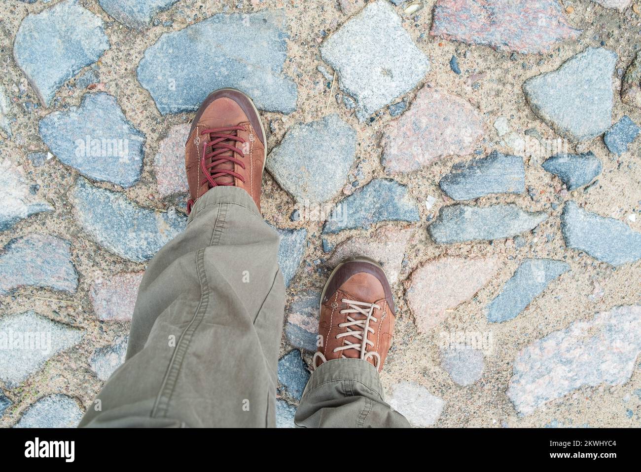 Feet in comfortable trekking shoes, suitable for long walks, stand on ...