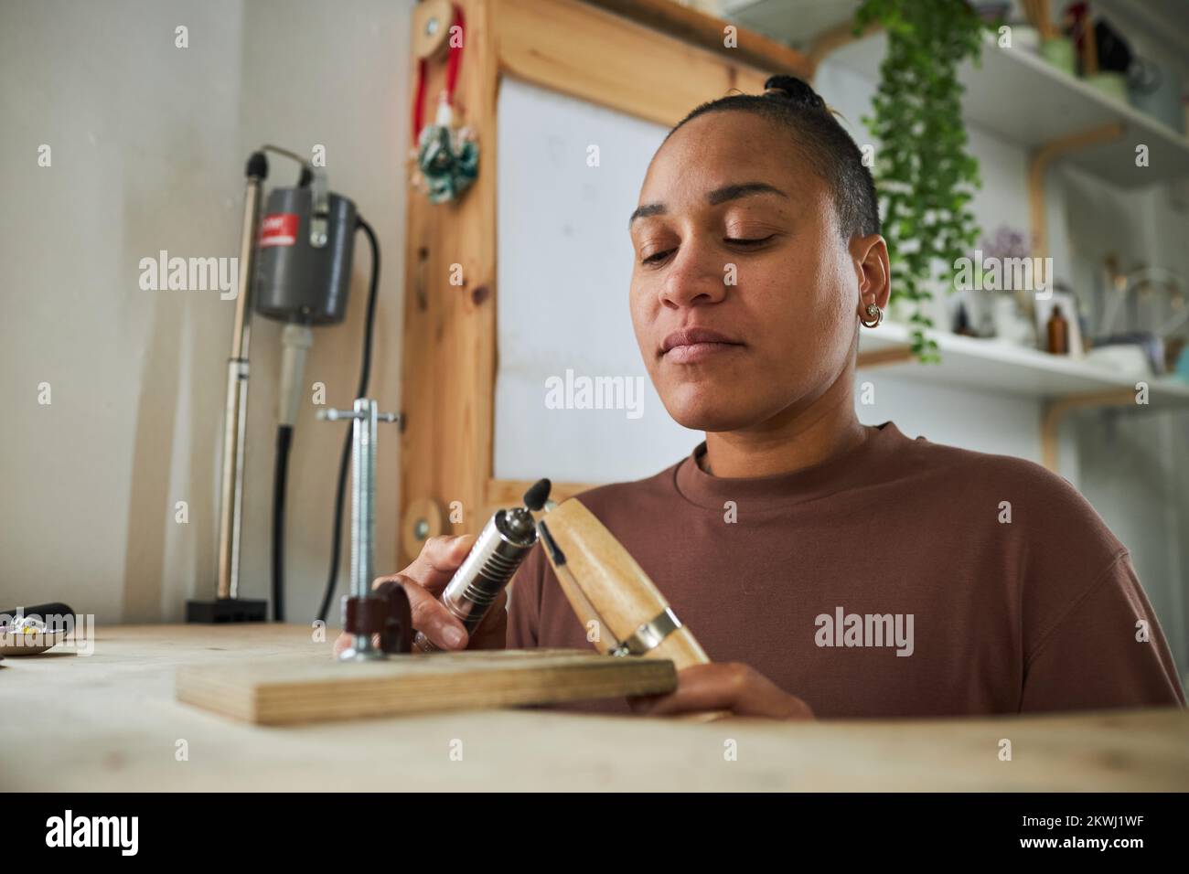 Close up portrait of black woman creating handmade jewelry in workshop ...