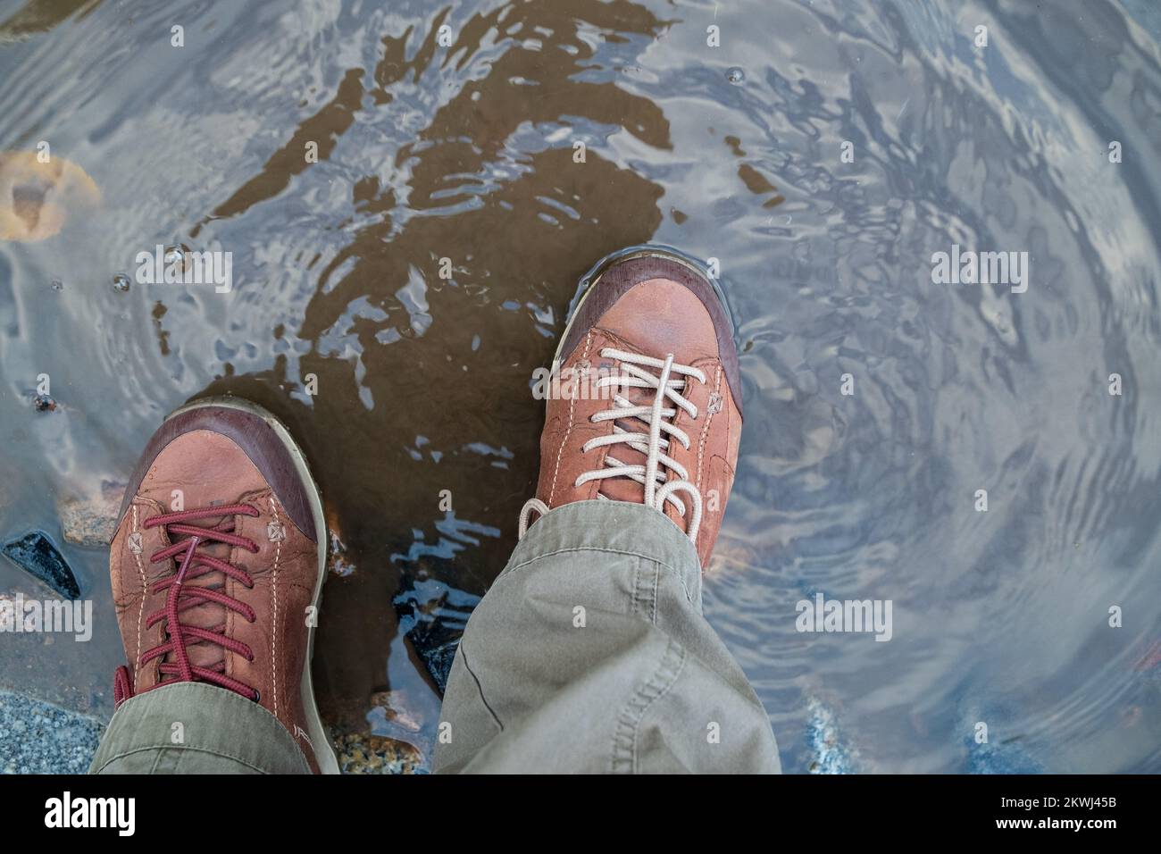 Feet in comfortable trekking shoes suitable for long walks stand in a ...