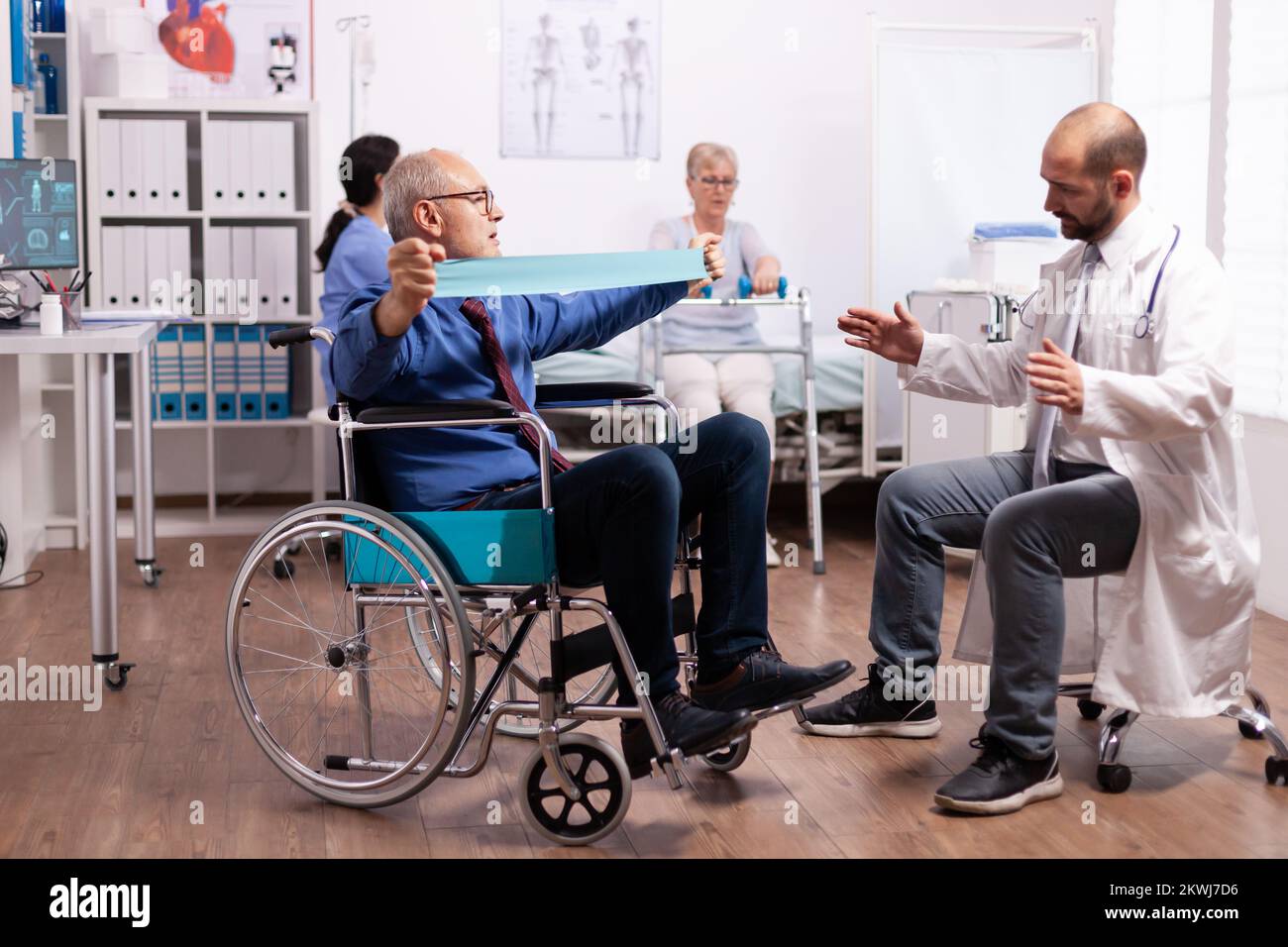Disabled senior man doing his exercises in hospital with doctor ...