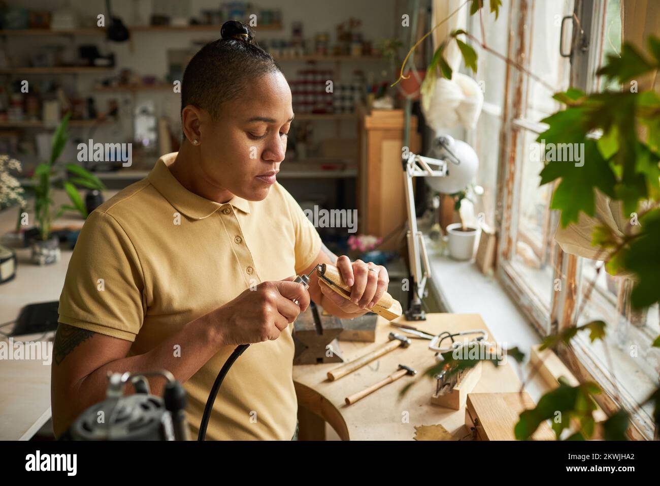 Portrait of black female artist working on handmade jewelry in cozy ...