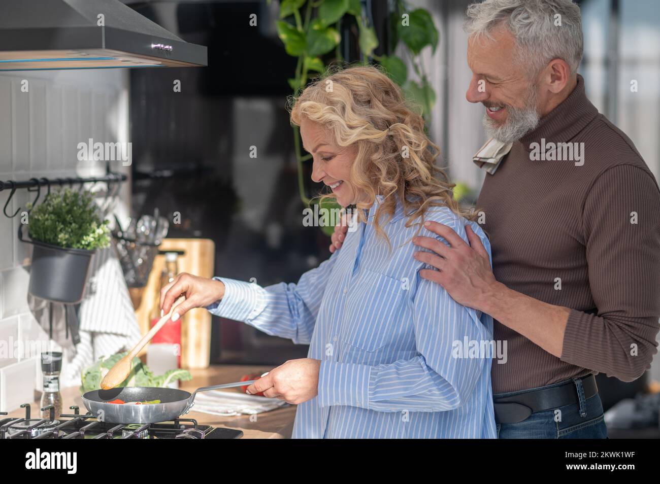 Mature Couple In The Kitchen Looking Happy While Cooking Breakfast