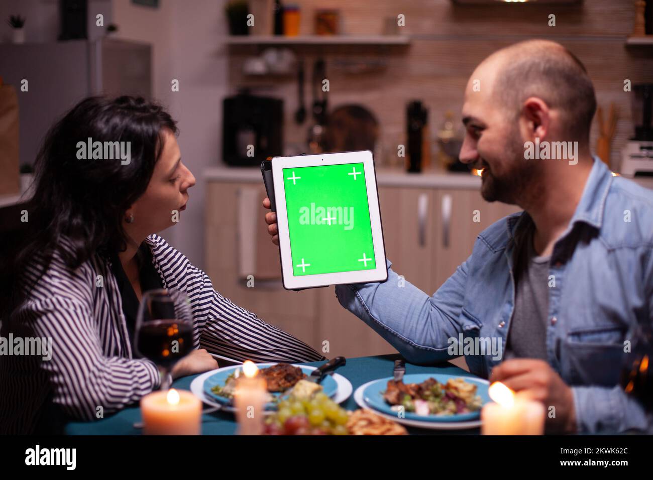 Couple using tablet pc with chroma key and enjoying their time together ...