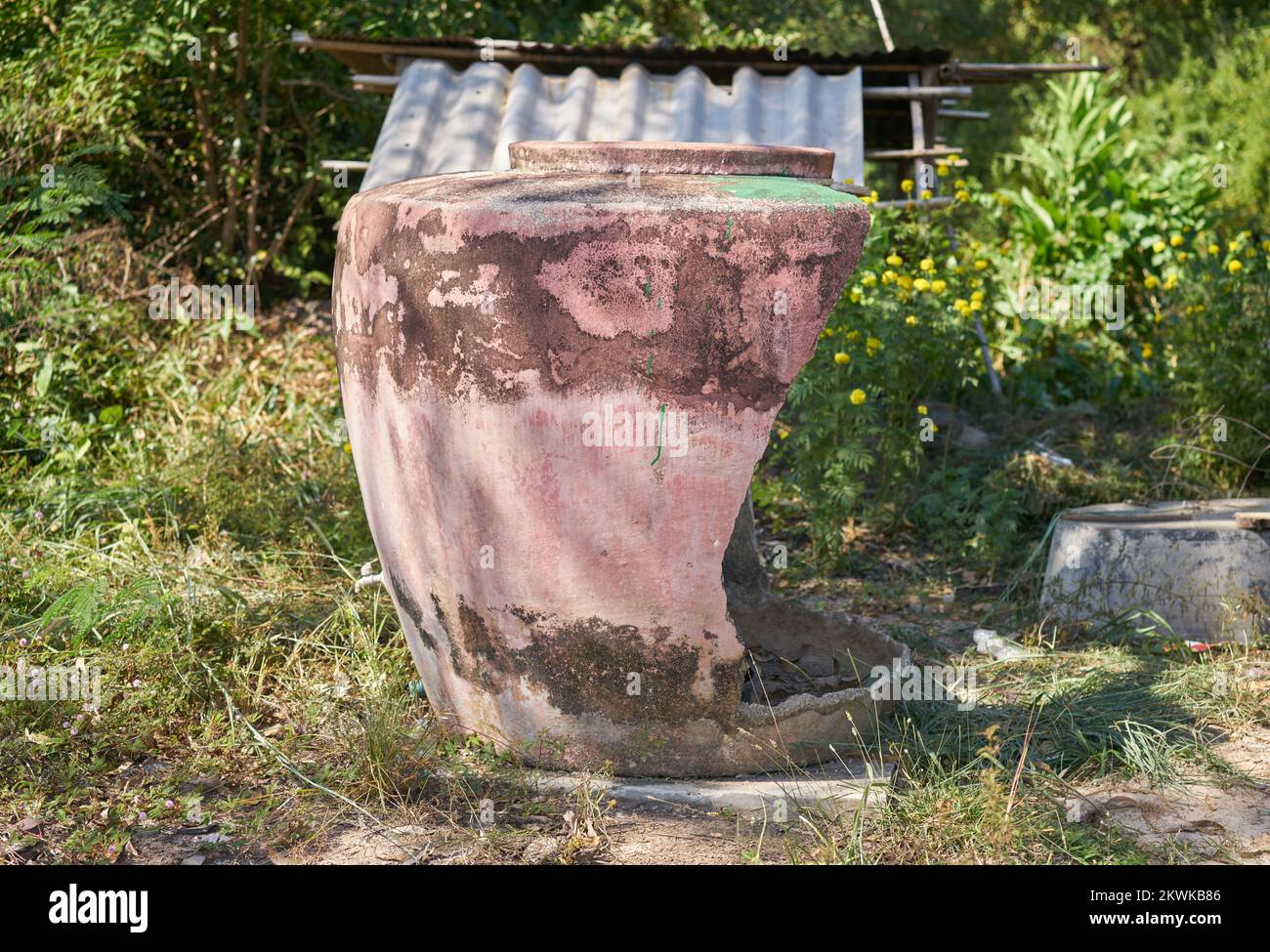 A large traditional damaged water jar on na farm in rural Thailand ...