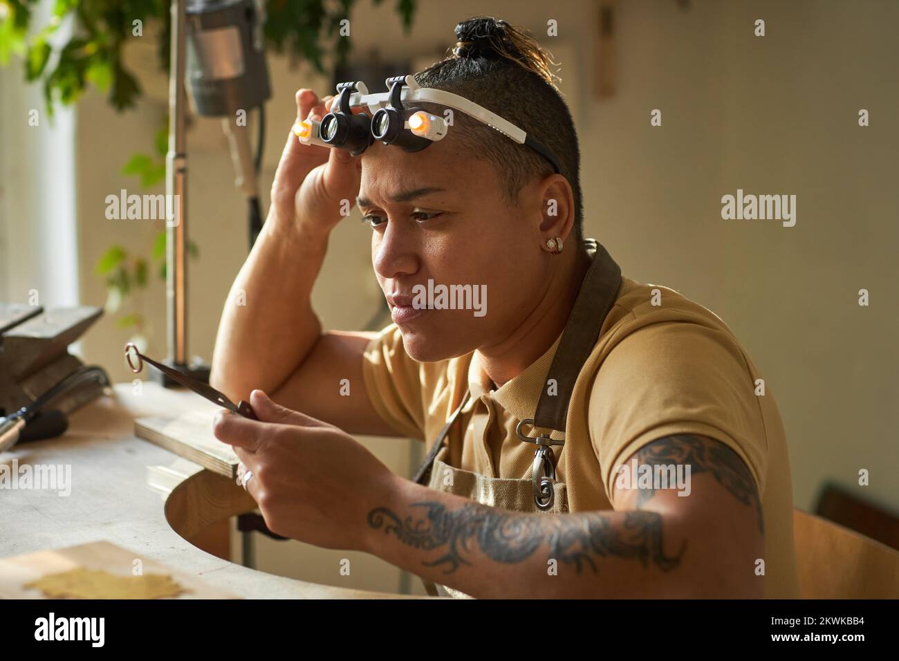 Side view portrait of black female jeweler creating handmade gold ring ...