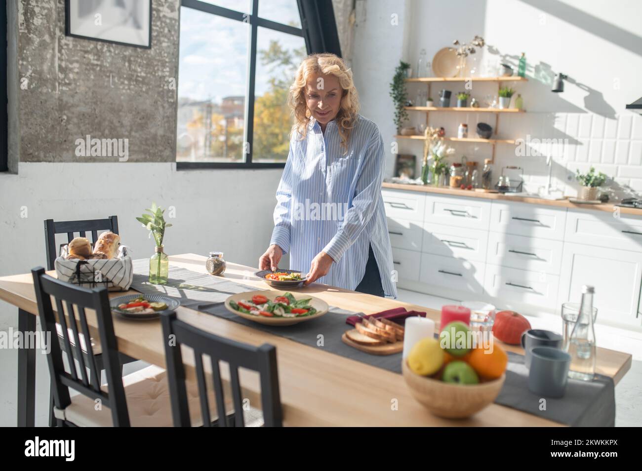 Blonde woman serving a table for breakfast Stock Photo - Alamy