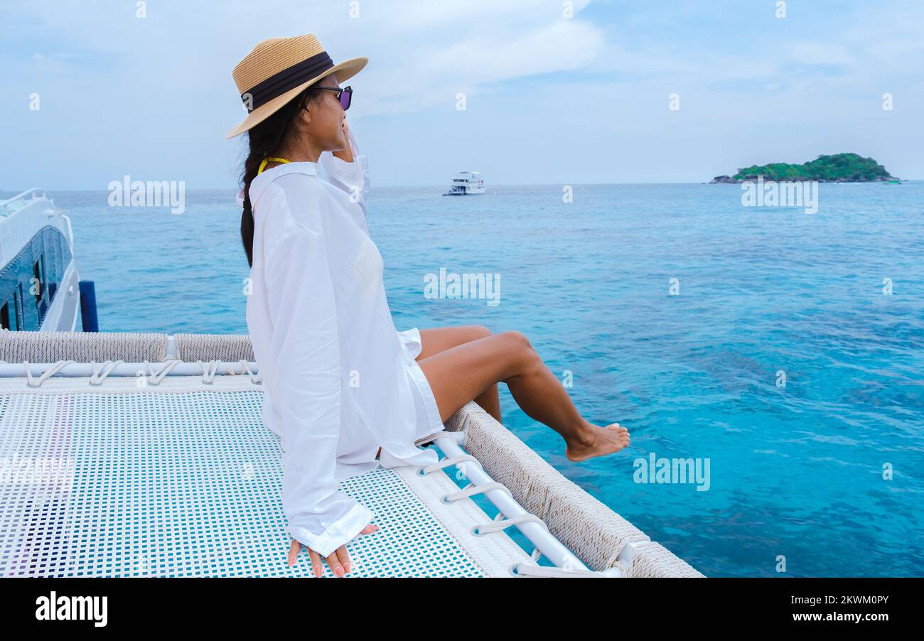 Asian Thai women on a boat trip at a catamaran near the Similan Islands ...
