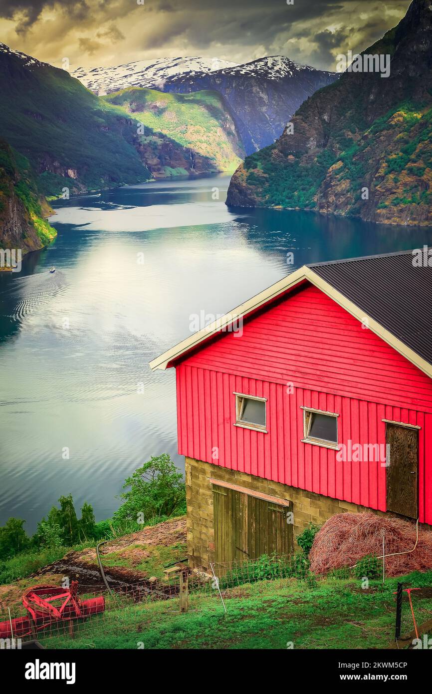 Norwegian rorbu above Aurlandsfjord with reflection and boat, Norway ...