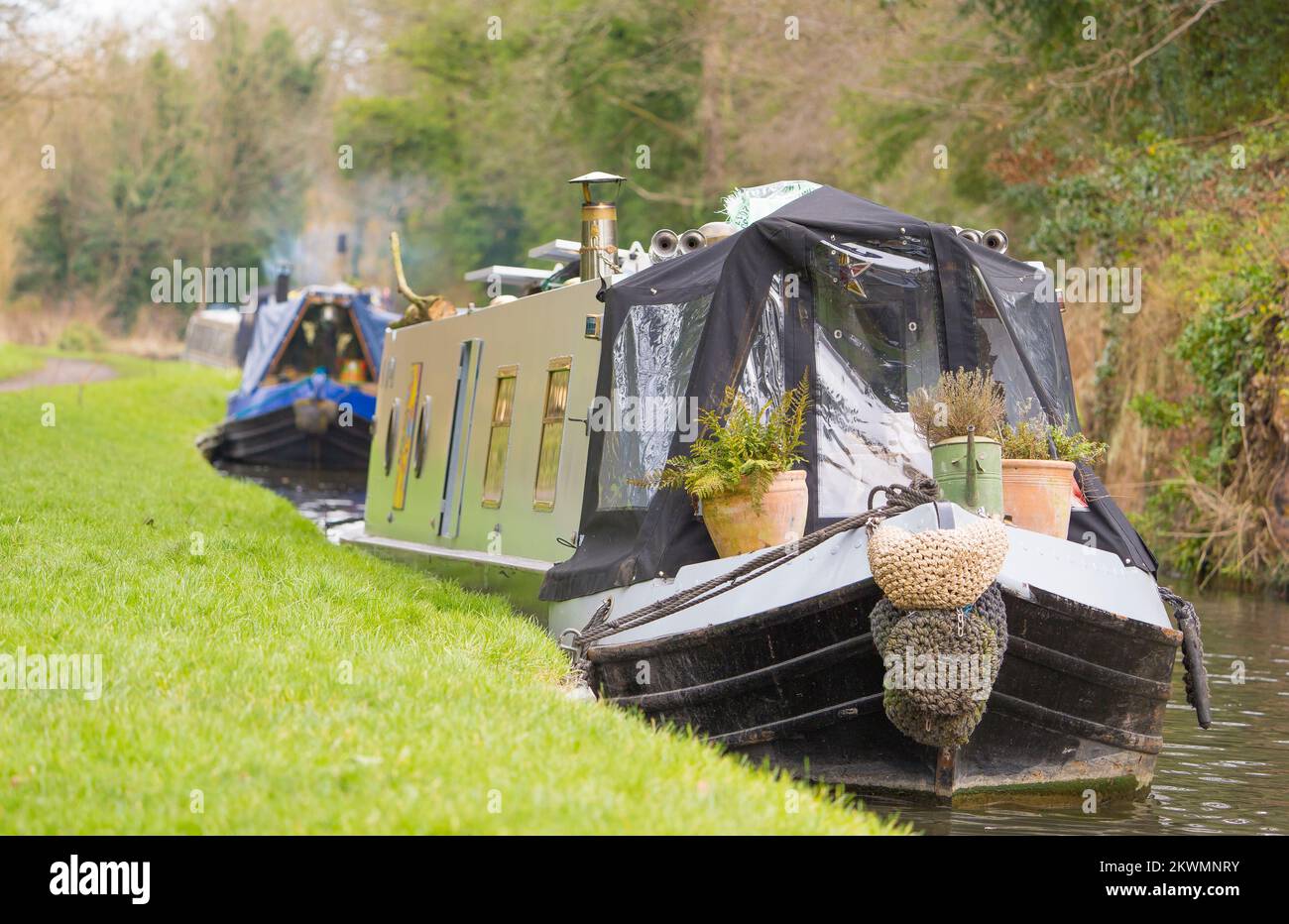 Canal boat moored to the canal path with a log burner on board smoking ...