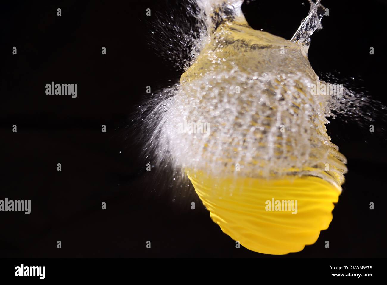 Splash of water balloon on black background Stock Photo - Alamy