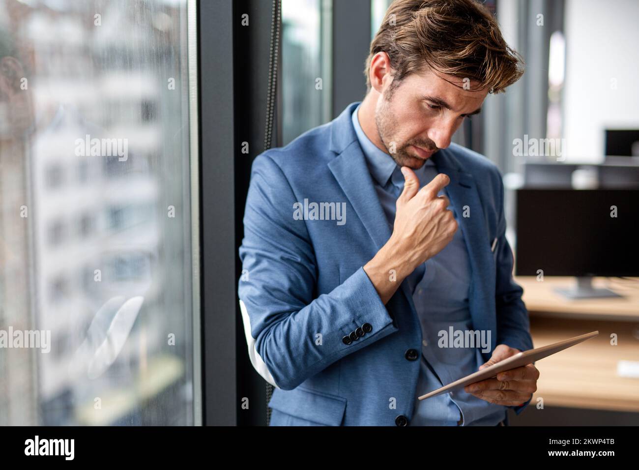 Happy business man manager holding tablet and working in modern office ...