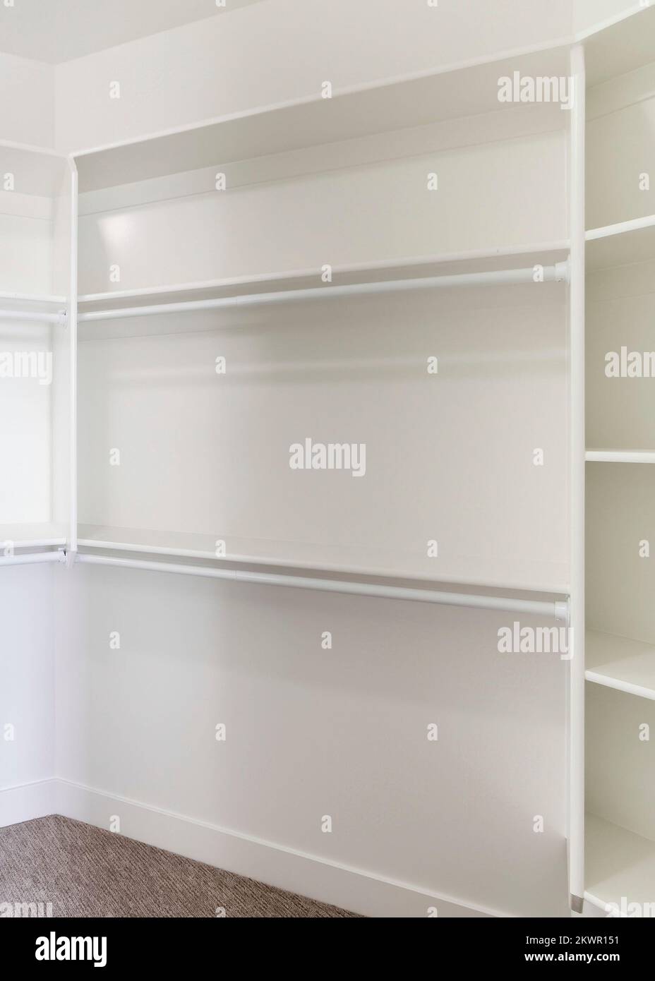 Vertical White built in wall mount shelving unit in a walk in closet ...