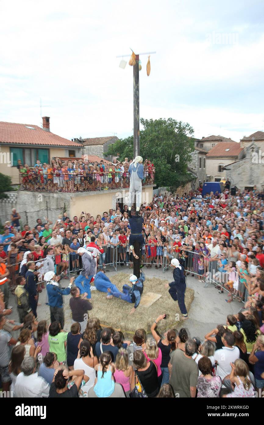 Men participate in the traditional competition of climbing up the ...