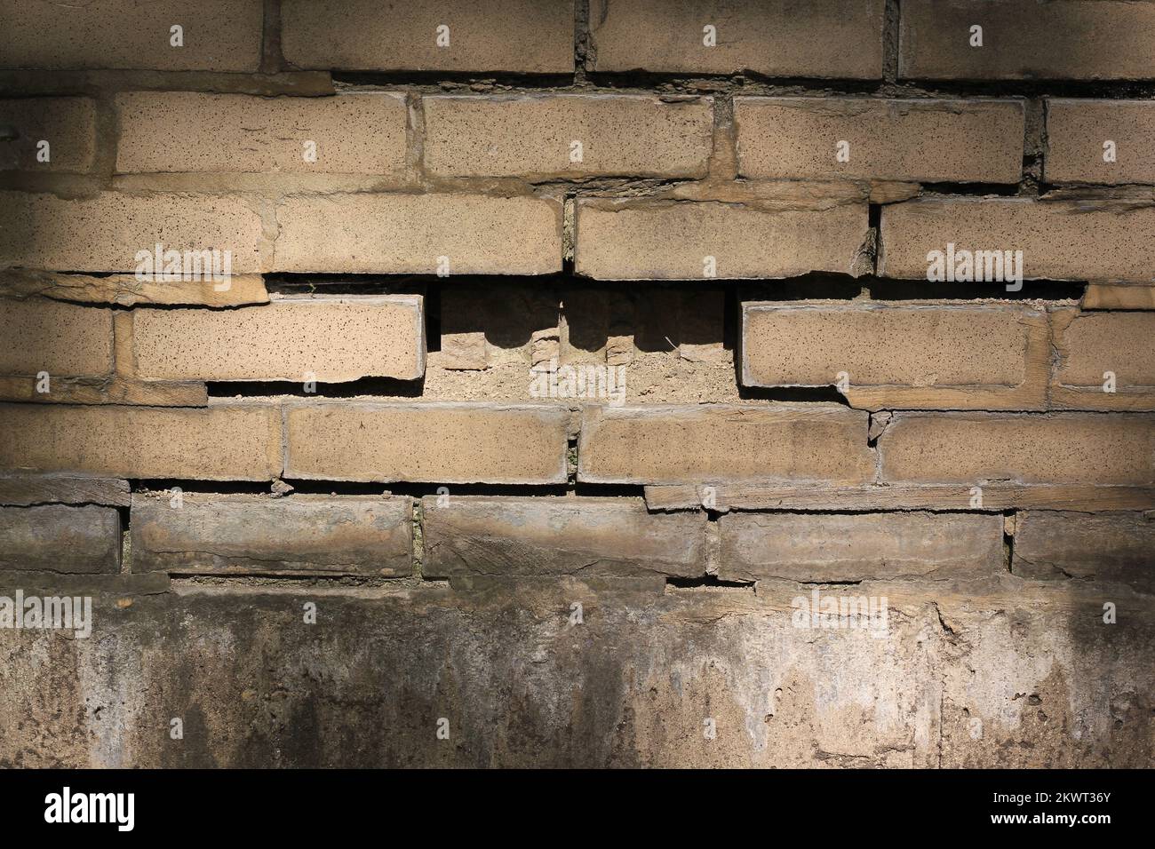 Typical common brick wall with a missing piece Stock Photo - Alamy