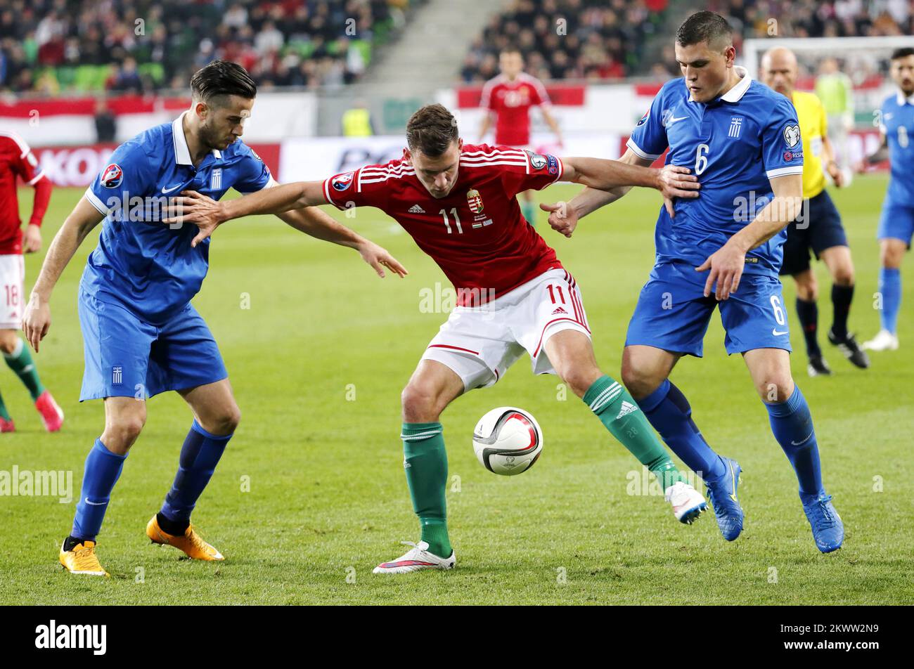 Hungary's Adam Szalai (centre) holds off Greece's Kostas Manolas (left ...