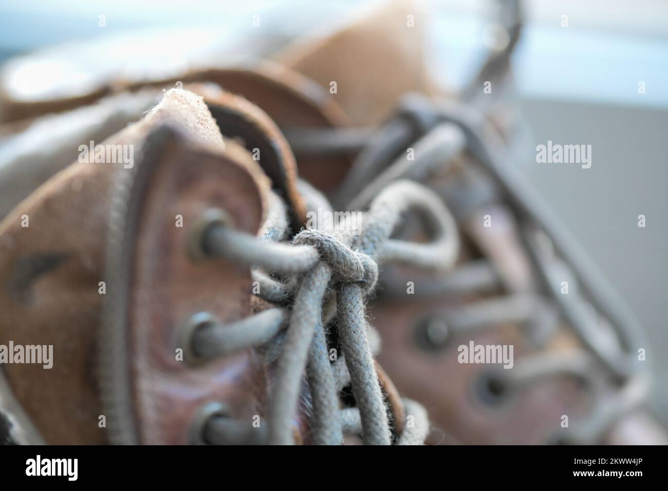 A close up of old weathered brown leather working boots with badge ...