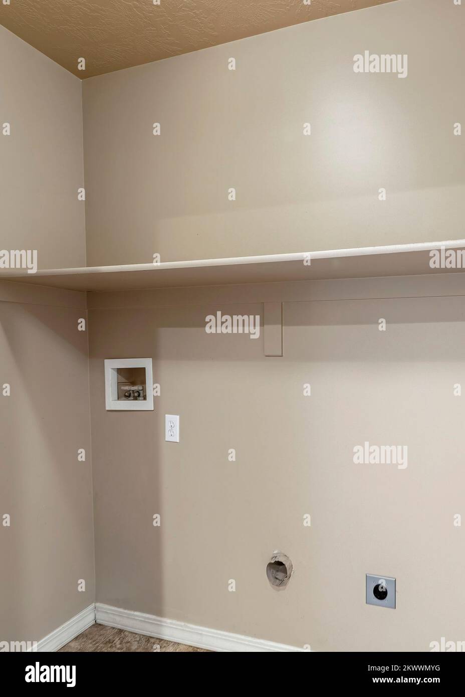 Vertical Empty laundry room interior with wall mounted shelf. There are ...