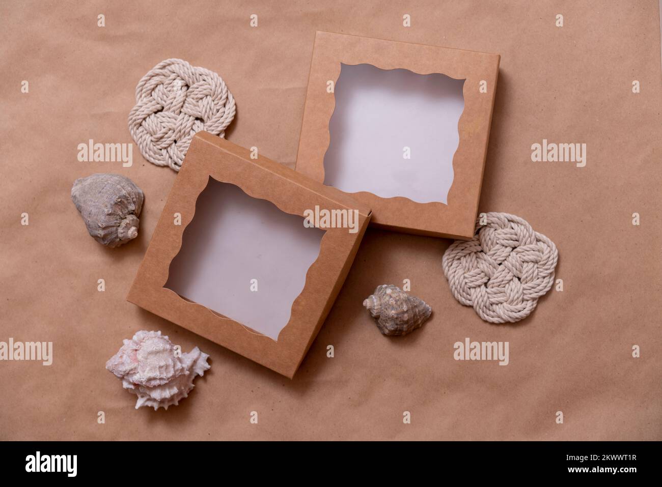 Two boxes with a transparent lid on craft paper with seashells and ...