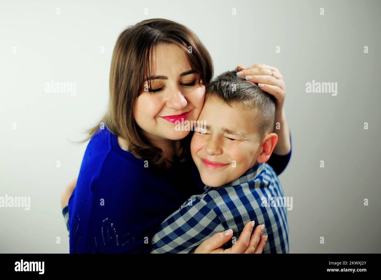 hugs love family comfort Sad child hugging his mother Mom in a blue package tenderly hugs the ...