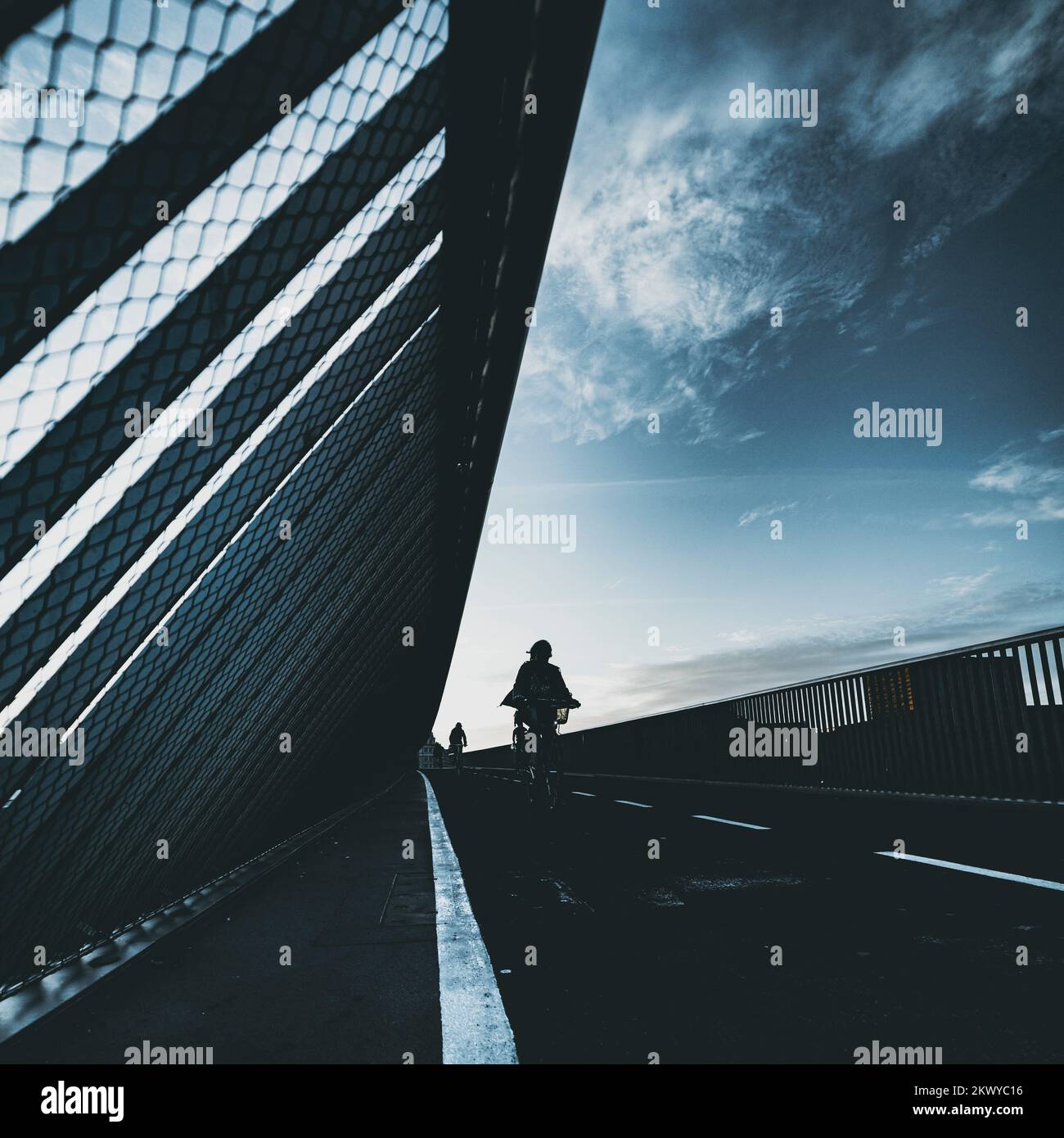 silhouette of the cyclist on the bridge, person riding trough the ...