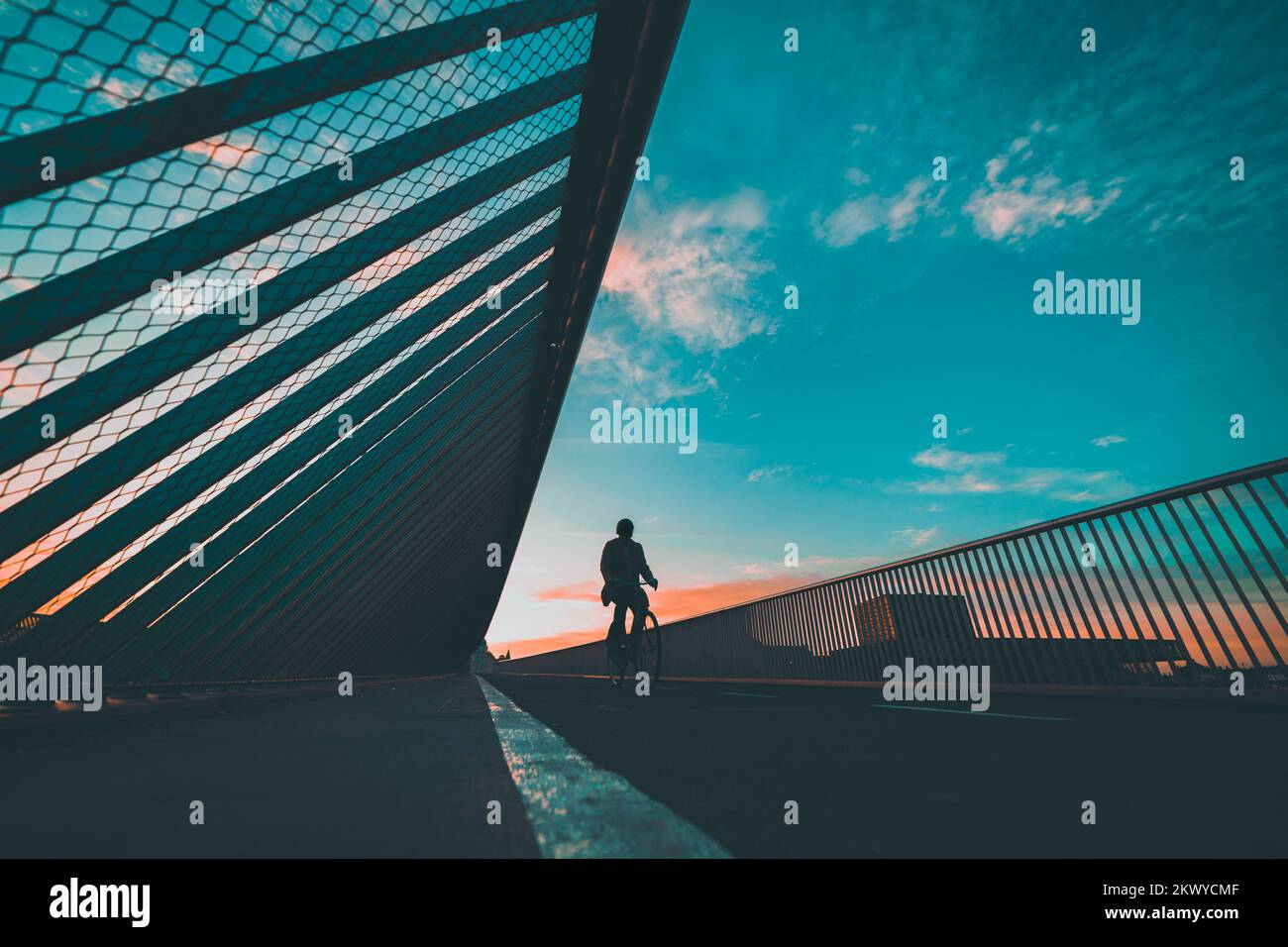 silhouette of the cyclist on the bridge, person riding trough the ...