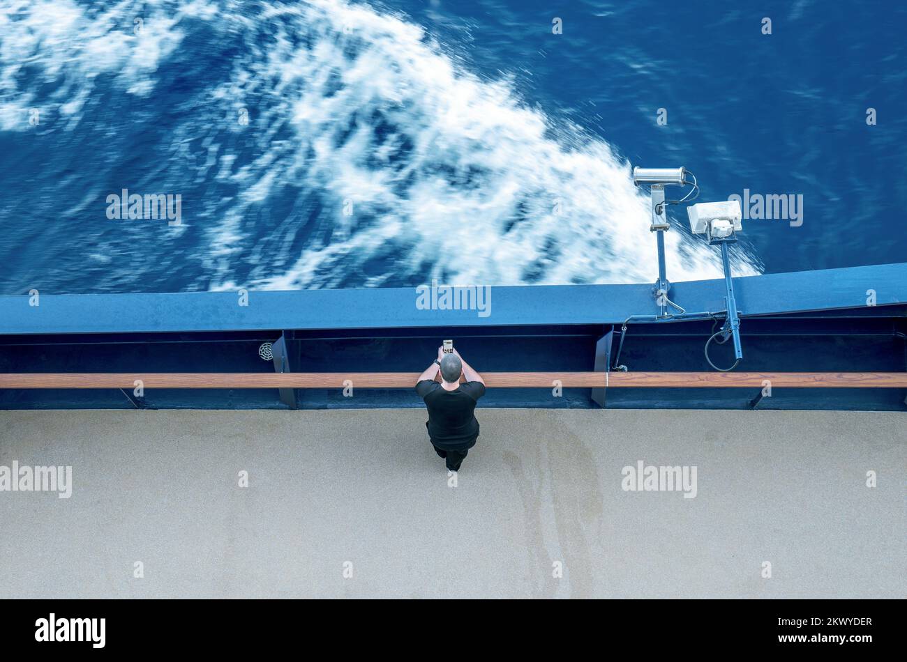 Single man on ship deck with cell phone in hands Stock Photo - Alamy
