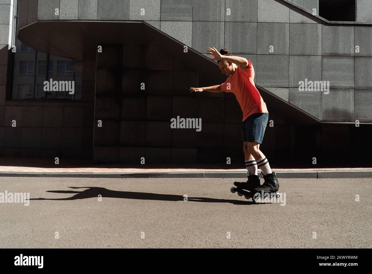 Side view of man in roller blades riding on urban street at daytime ...