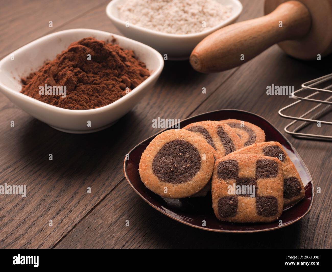 Black and white cookies on a wooden kitchen table with baking utensils ...