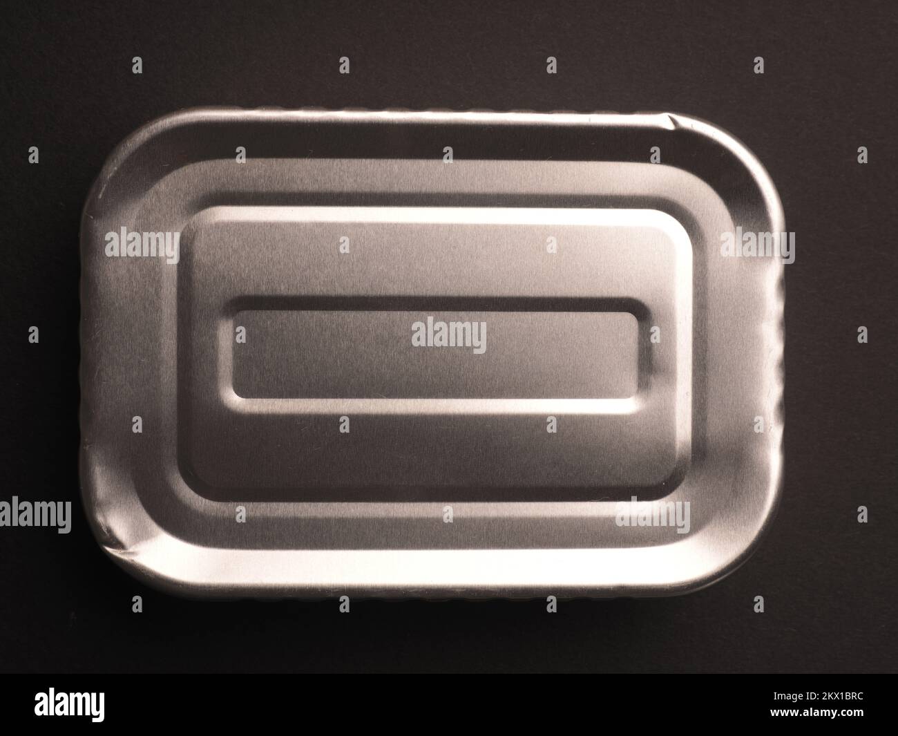 Bottom of aluminum fish can on a dark background Stock Photo - Alamy